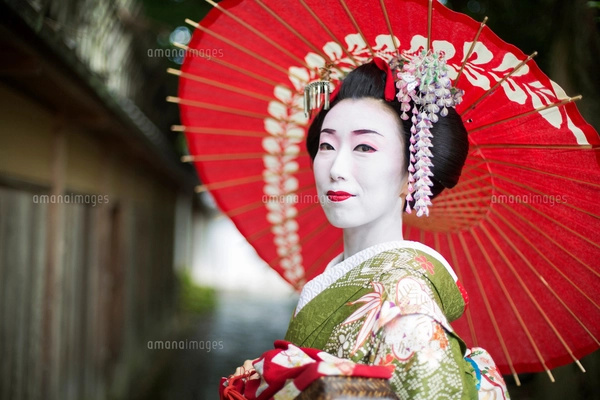 A woman dressed in the traditional geisha style, wearing a kimono and ...