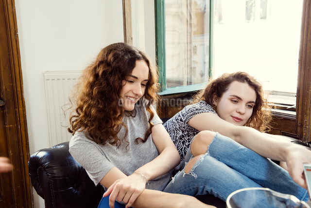 Two young female friends sitting on armchairの写真素材 [FYI03608486] | ストック ...