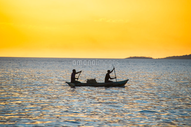Backlight of fishermen in a little fishing boat at sunset, Lake Malawi ...